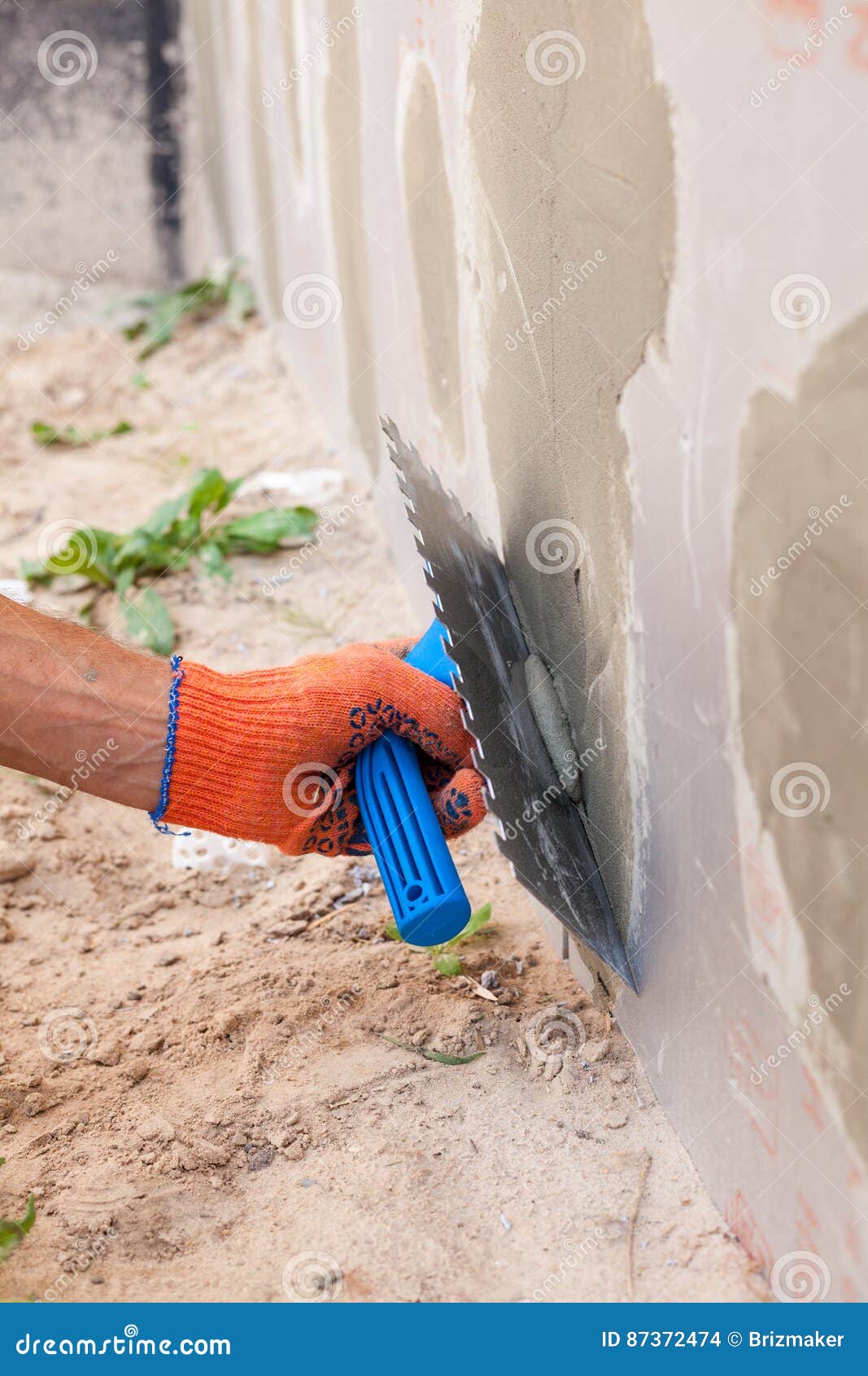 Construction Worker Plastering a Wall and House Foundation with Trowel ...
