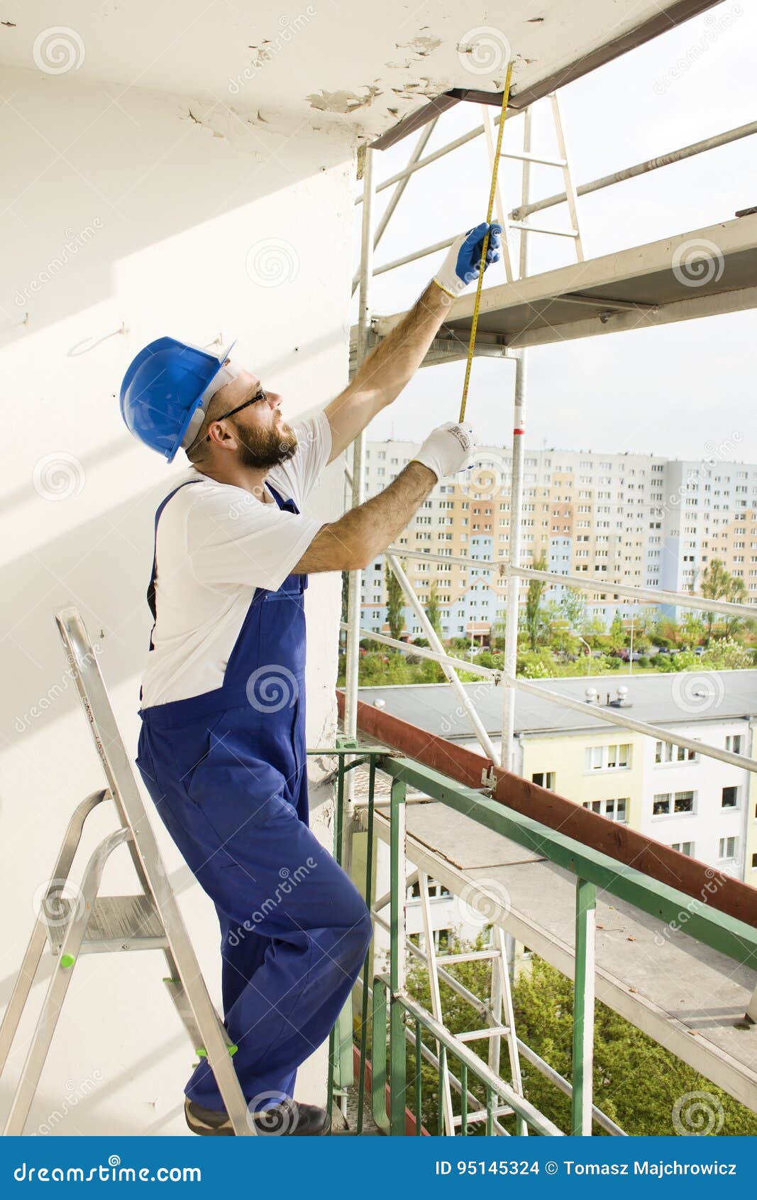 Construction Worker in a Protective Helmet and Work Attire Measures ...