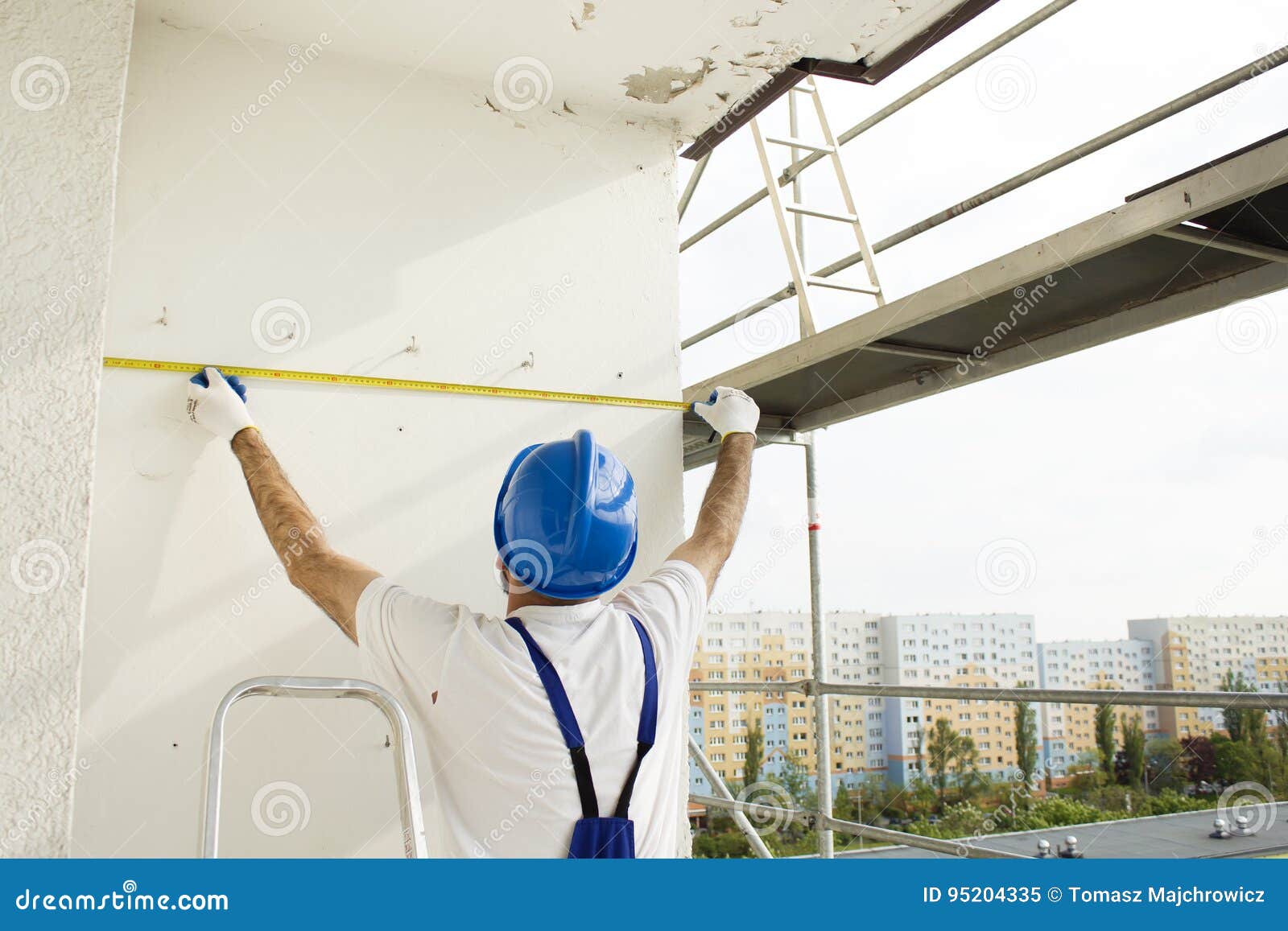 Construction Worker in a Protective Helmet and Work Attire Measures ...