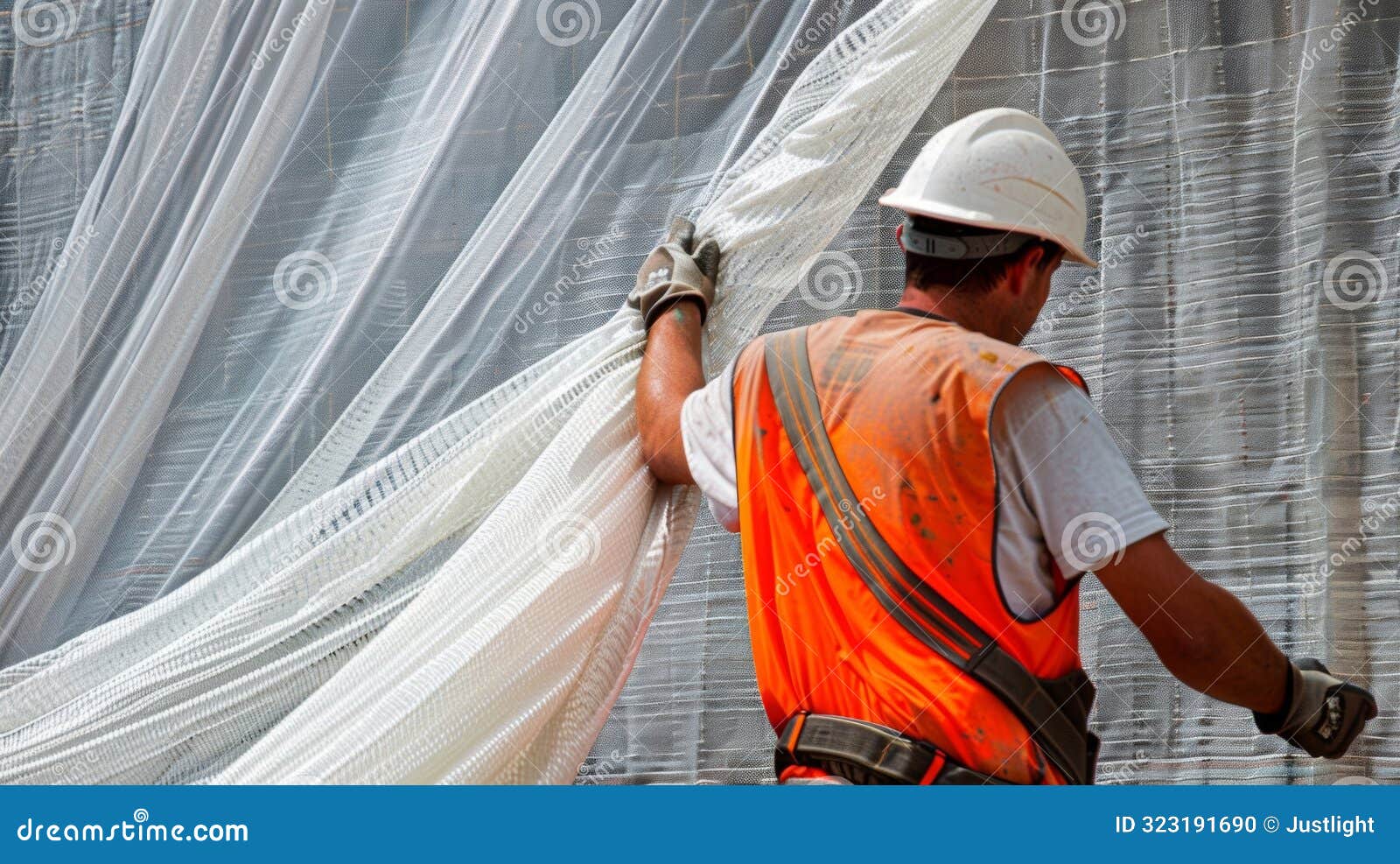A Construction Worker Pulls Taut a Piece of White Mesh Safety Netting ...