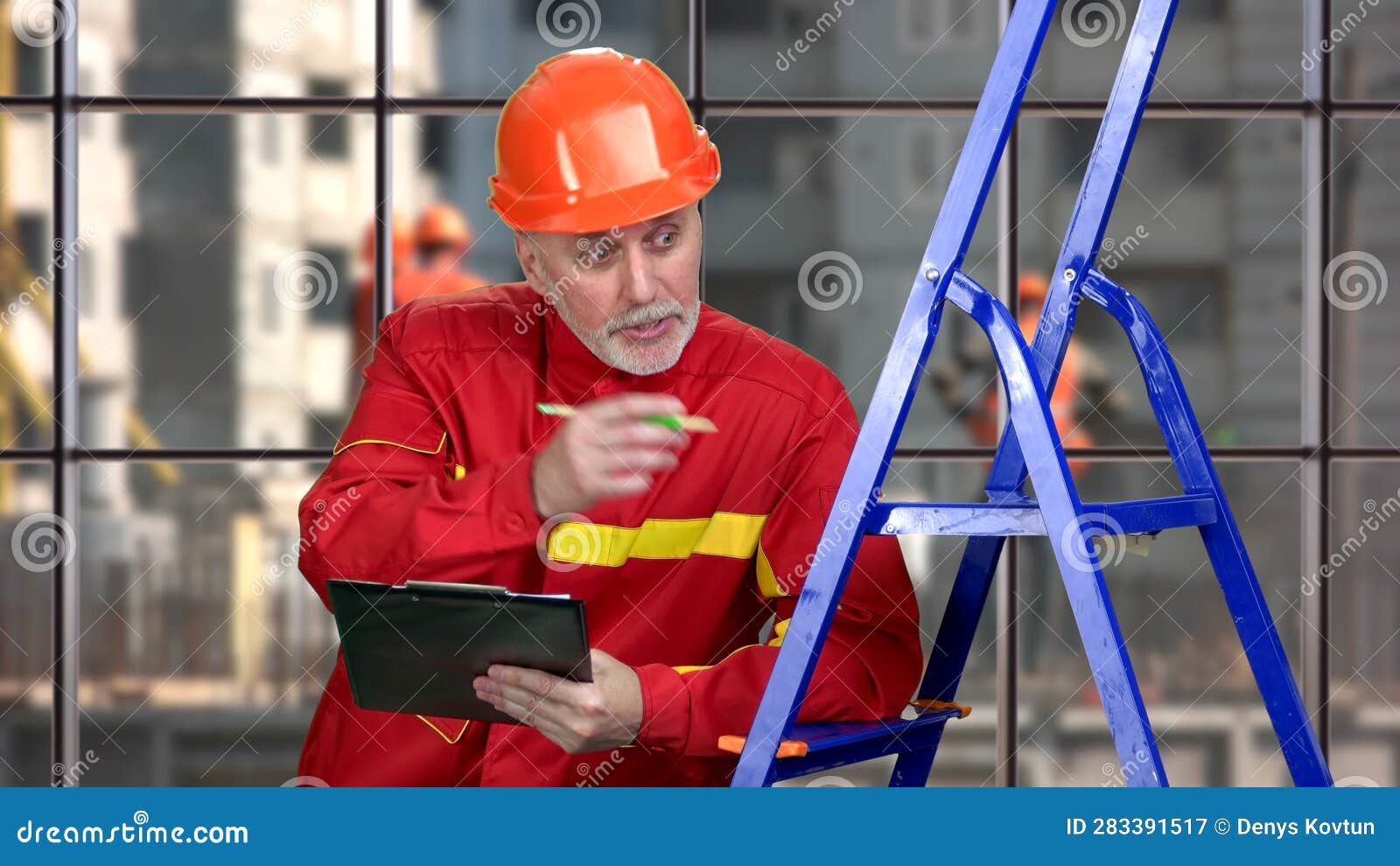 Construction Worker in Red Uniform and Orange Hardhat Writing Something ...