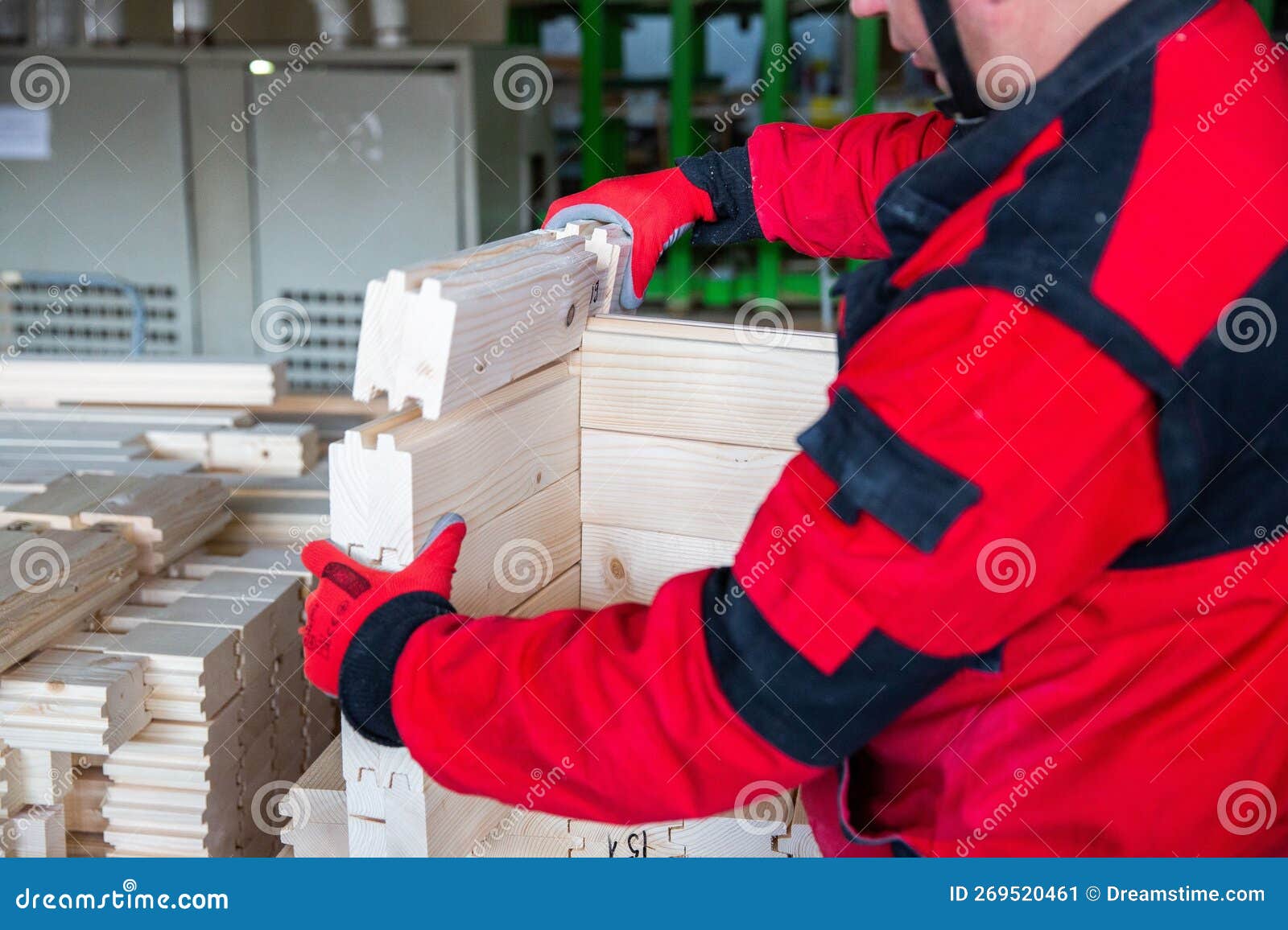Construction Worker in Red Workwear Working with a Wooden Structure on ...