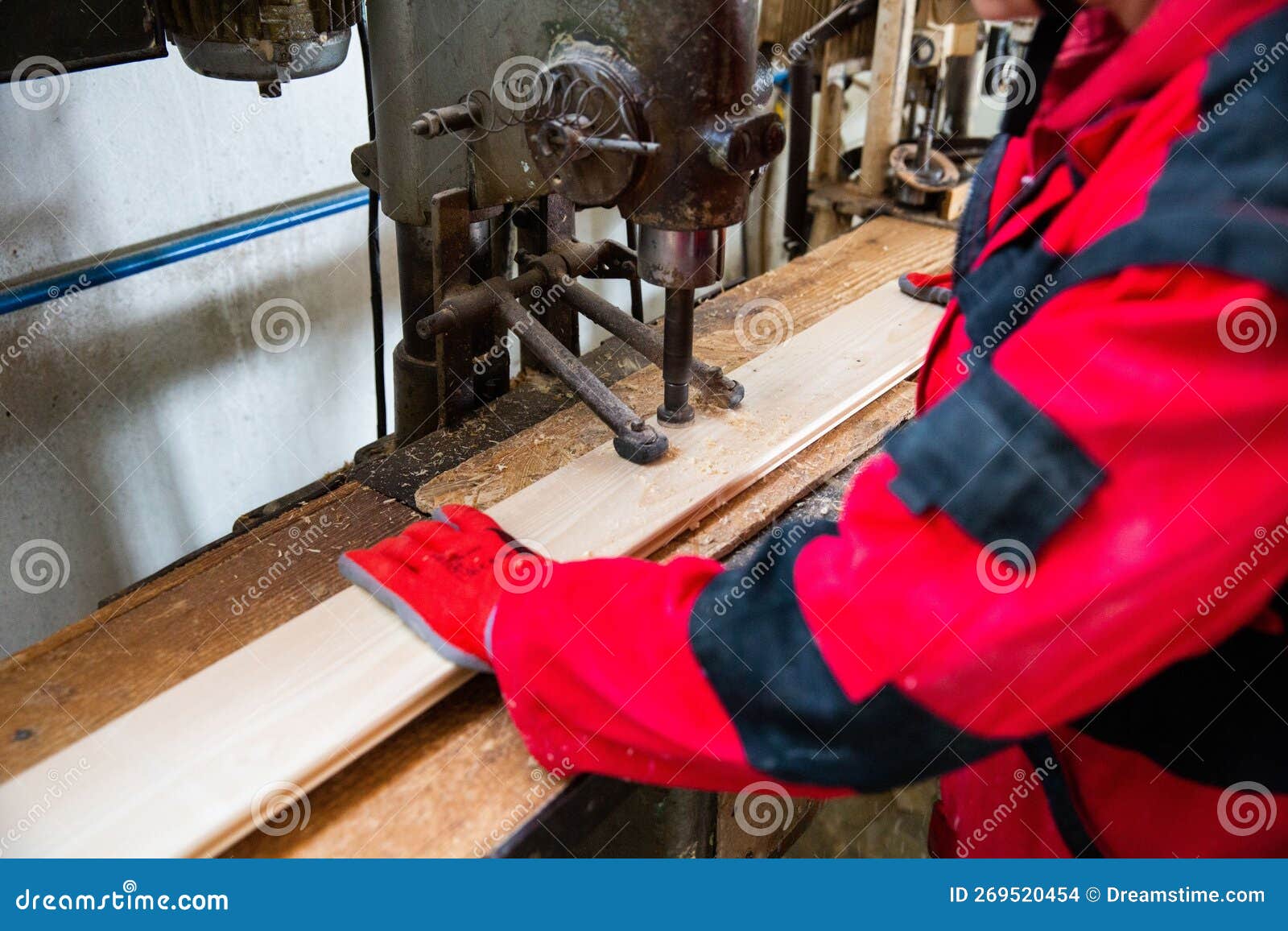 Construction Worker in Red Workwear Working with a Wooden Structure on ...