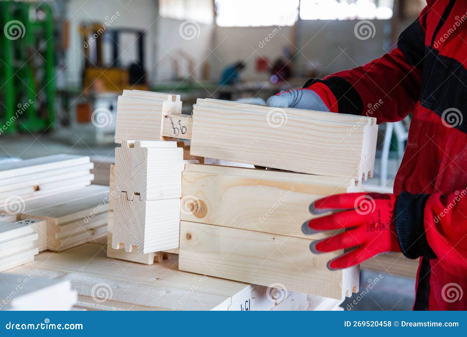 Construction Worker in Red Workwear Working with a Wooden Structure on ...