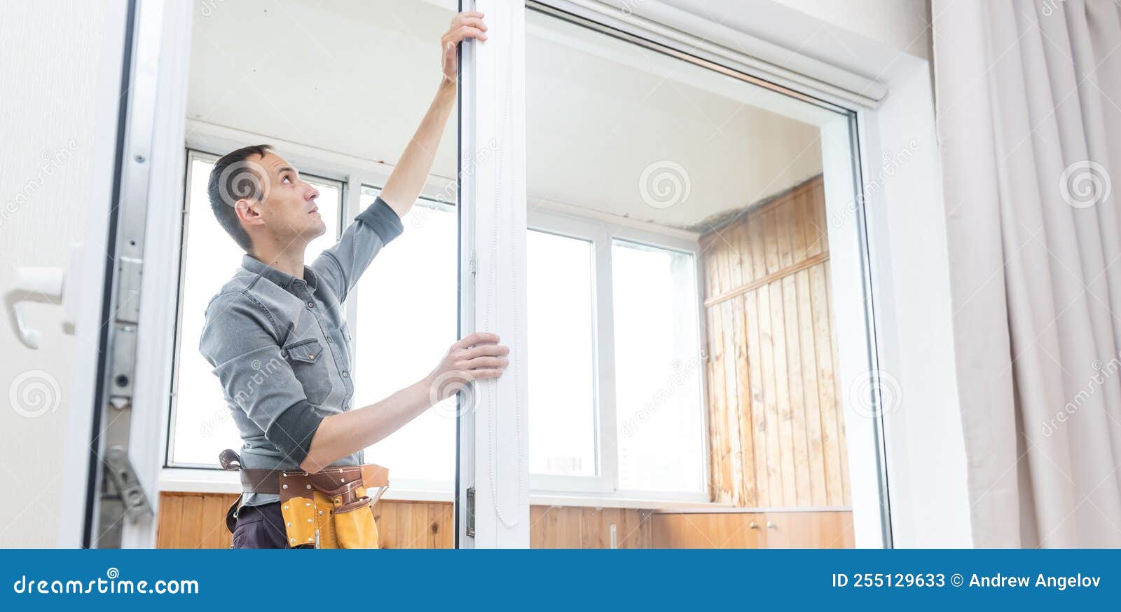 Construction Worker Removing Sticky Tape from Window Frame in House ...