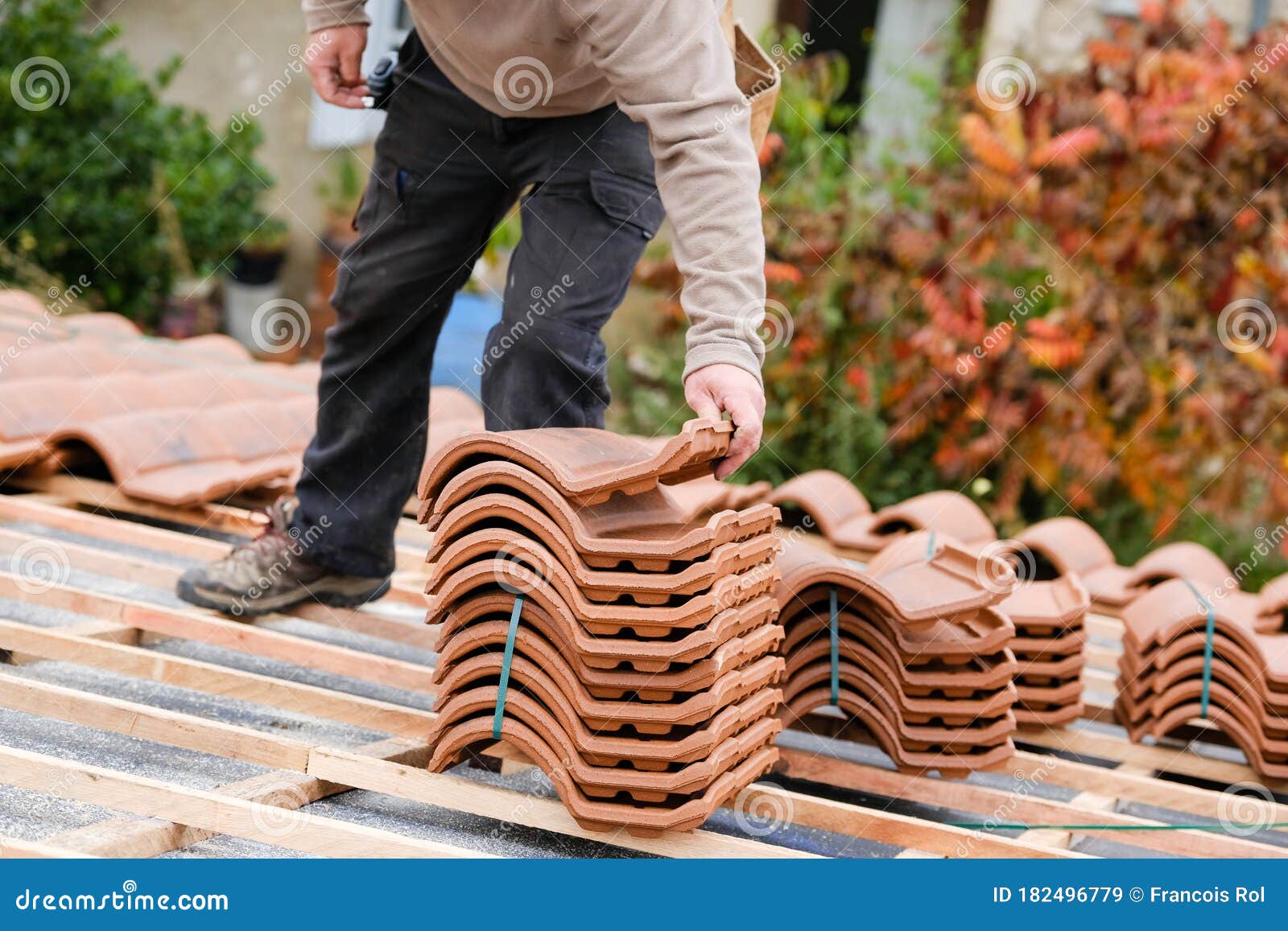 Construction Worker on a Renovation Roof Unloading Packages of Tiles on ...