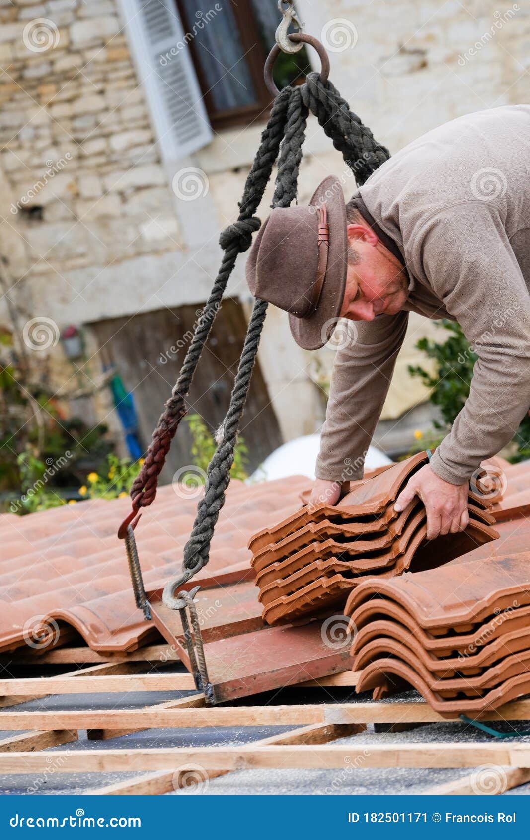 Construction Worker Unloading a Pile of Tiles Delivered To the Roof ...