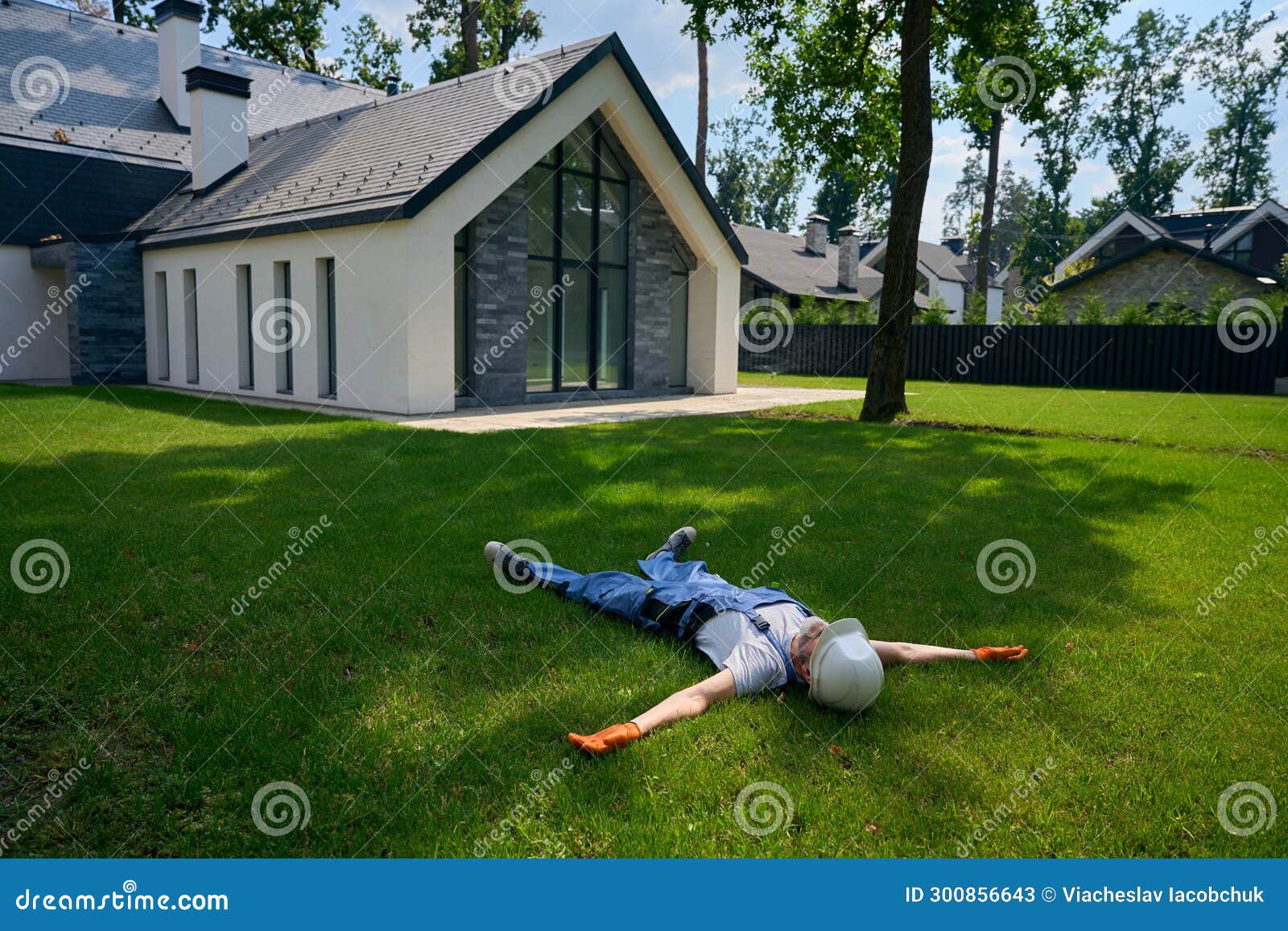 Construction Worker Resting on Green Grass Outside New Building Stock ...