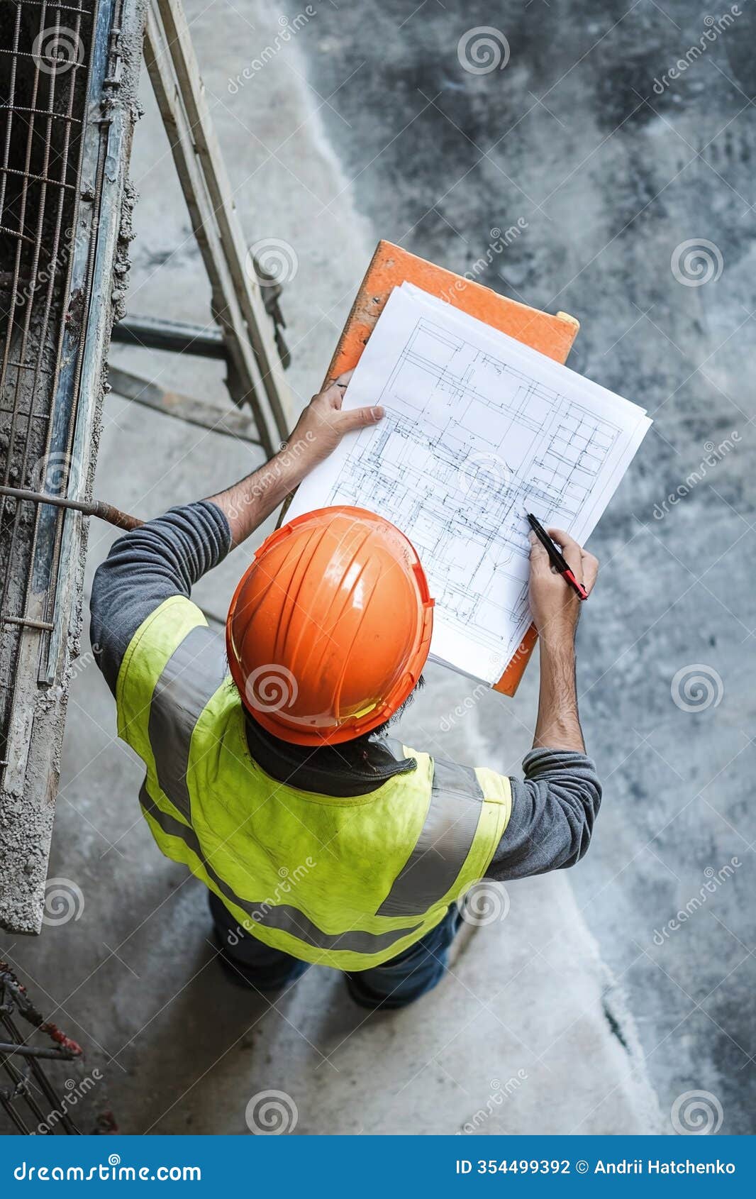 Construction Worker Reviewing Blueprints while Adhering To Safety ...