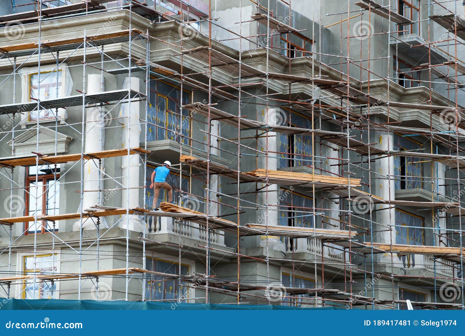 Construction Worker is on Scaffold, Modern Building Under Construction ...