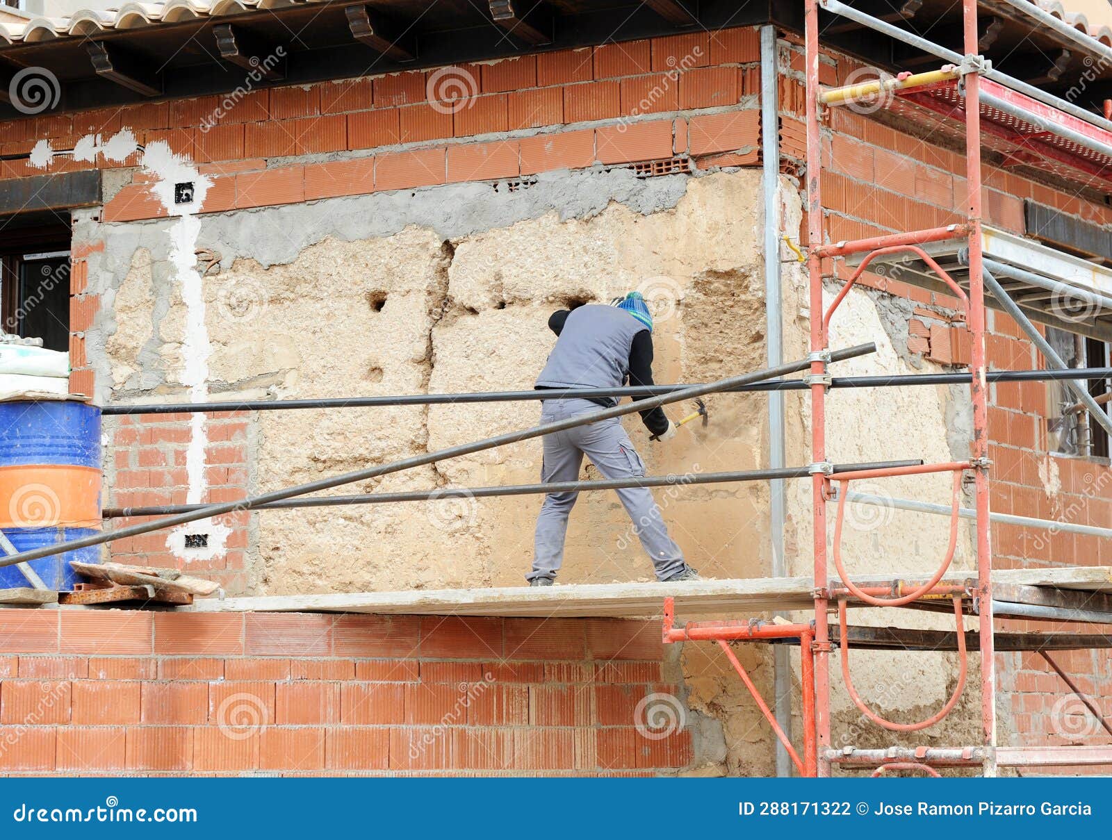 Construction Worker on Scaffold Using the Pickaxe in an Old Wall. Stock ...