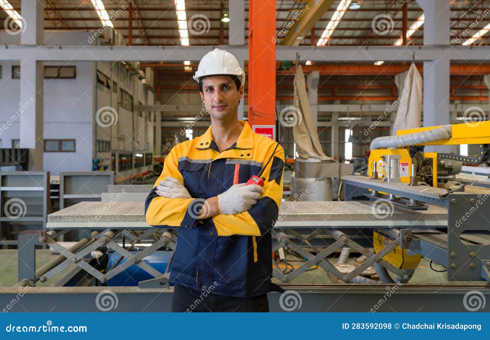 A Construction Worker Stand in Front of a Bustling Factory. he S ...