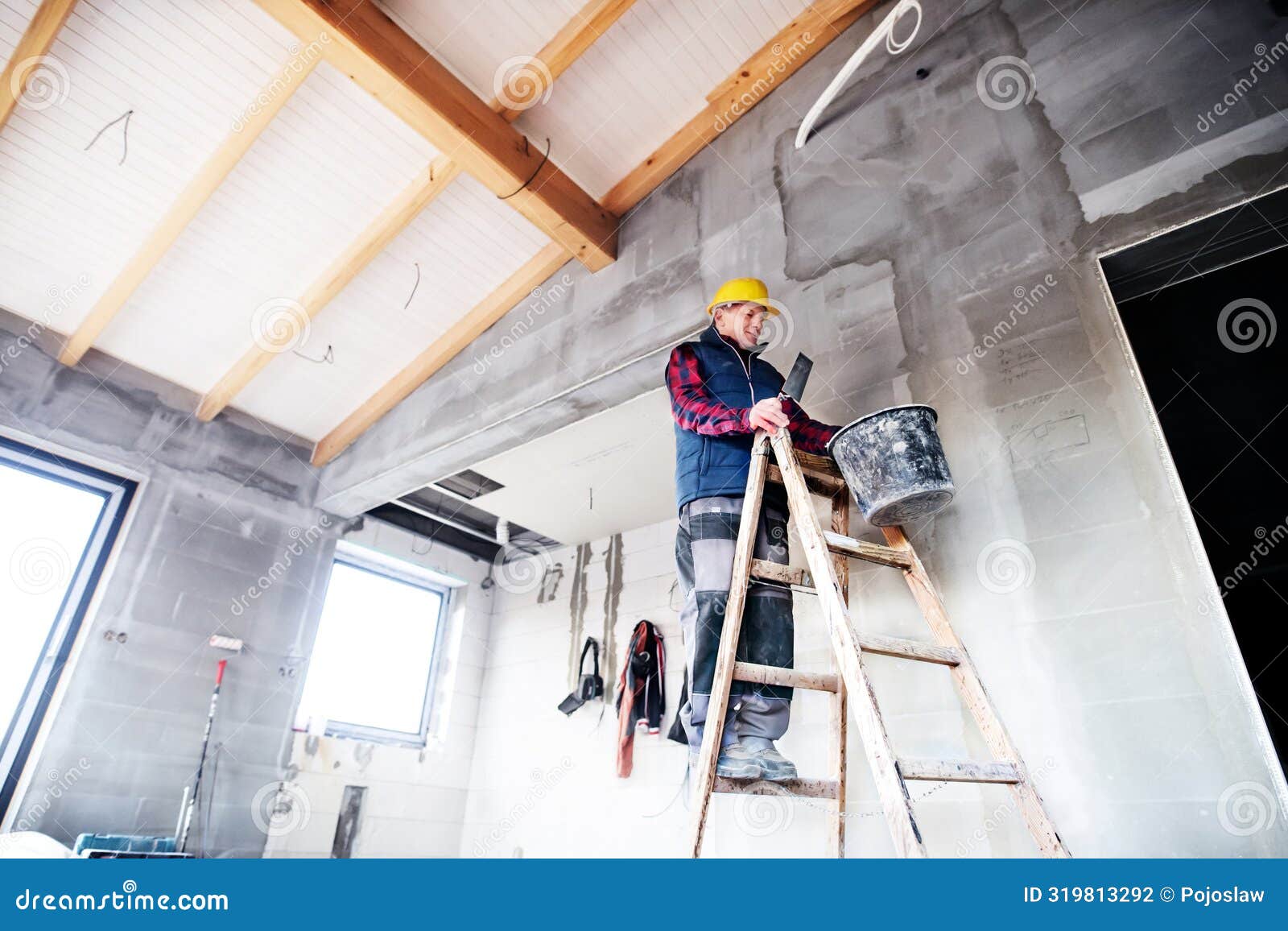 Construction Worker Standing on Ladder, Working on Wall. Stock Photo ...