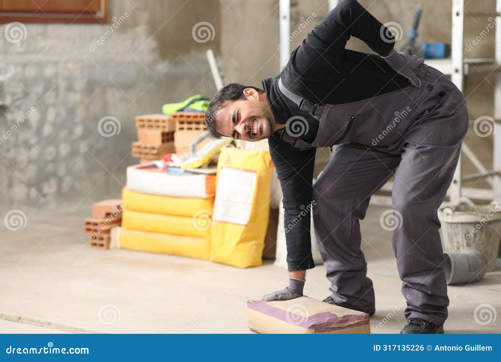 Construction Worker Suffering Back Ache Lifting a Weight Stock Photo ...