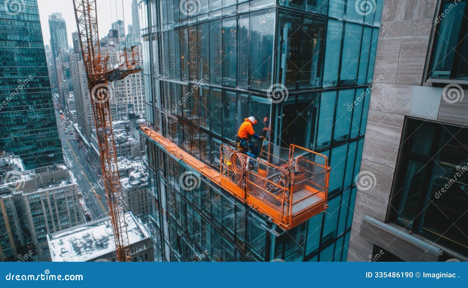 Construction Worker on a Suspended Platform Cleaning Windows on a ...