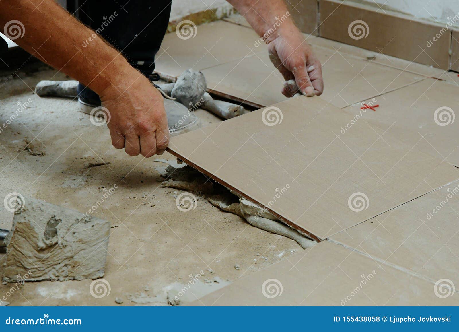 Construction Worker is Tiling Floor at Home. Laying Tiles on the Floor ...