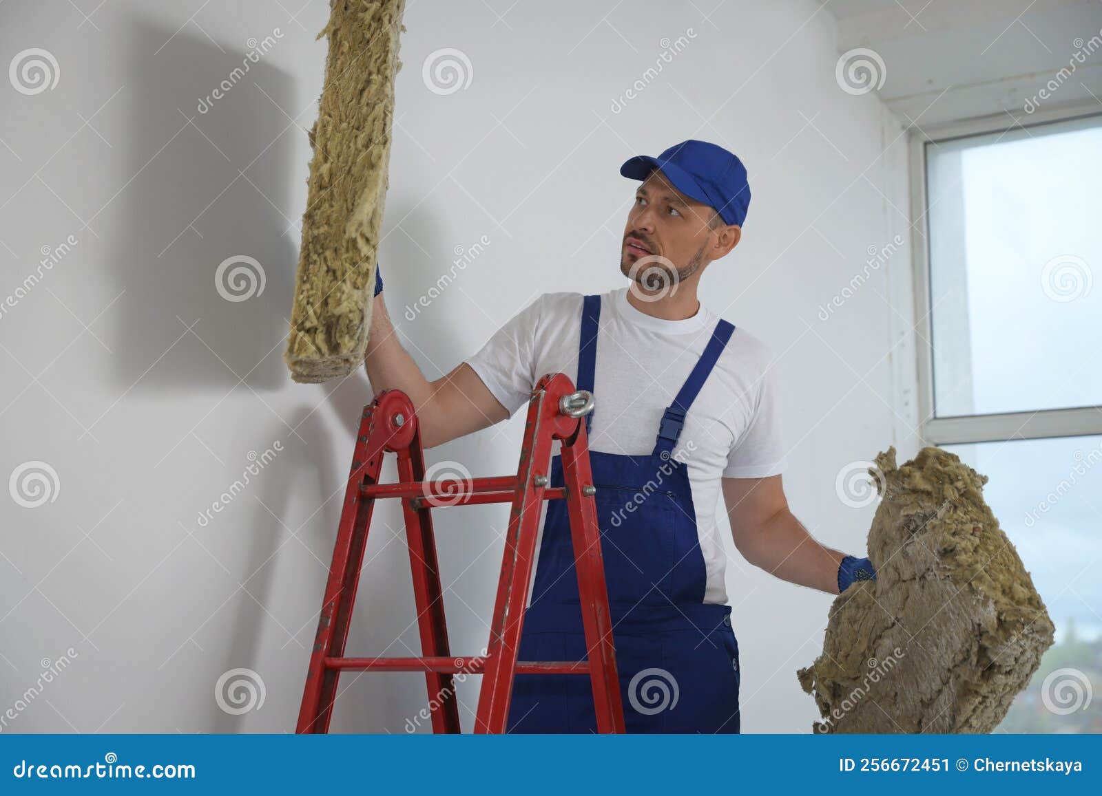 Construction Worker with Used Glass Wool on Stepladder in Room Prepared ...