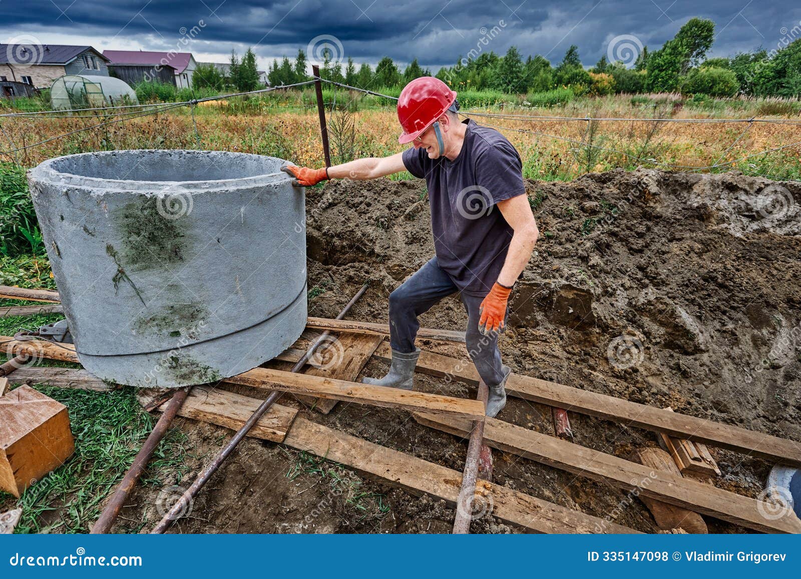 Construction Worker Uses Winch To Move Concrete Ring Along Sloping ...