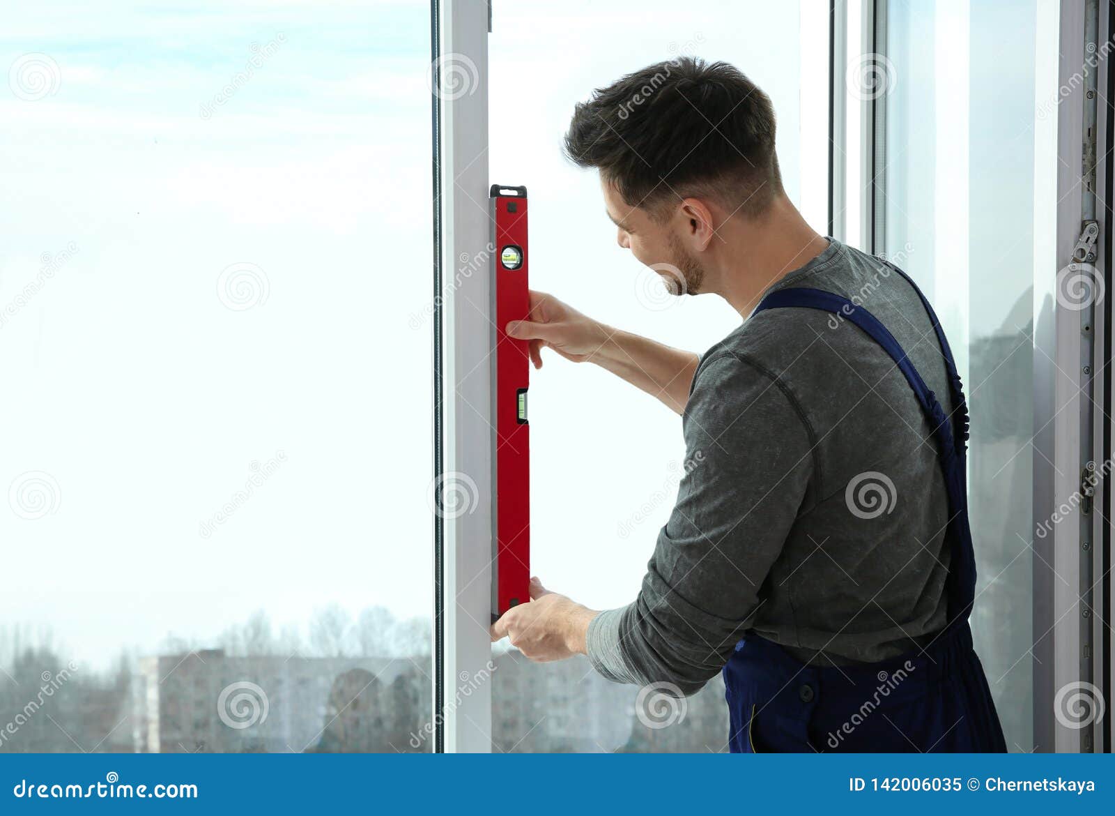Construction Worker Using Bubble Level while Installing Window Stock ...