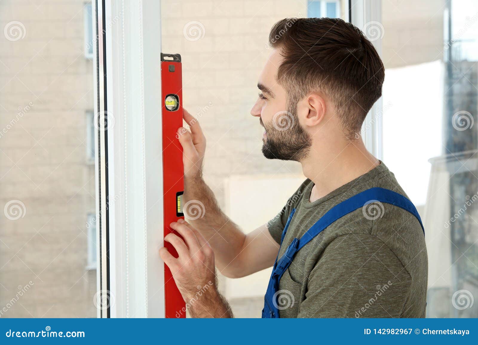 Construction Worker Using Bubble Level while Installing Window Stock ...