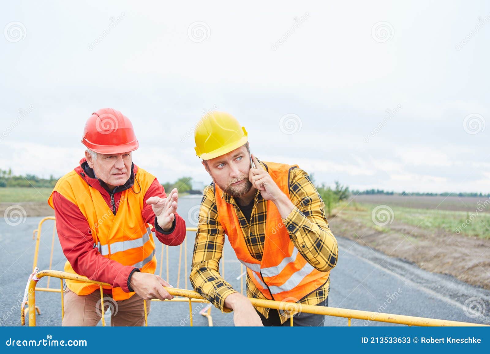 Construction Worker Using Cell Phone while Cordoning Off the Road Stock ...