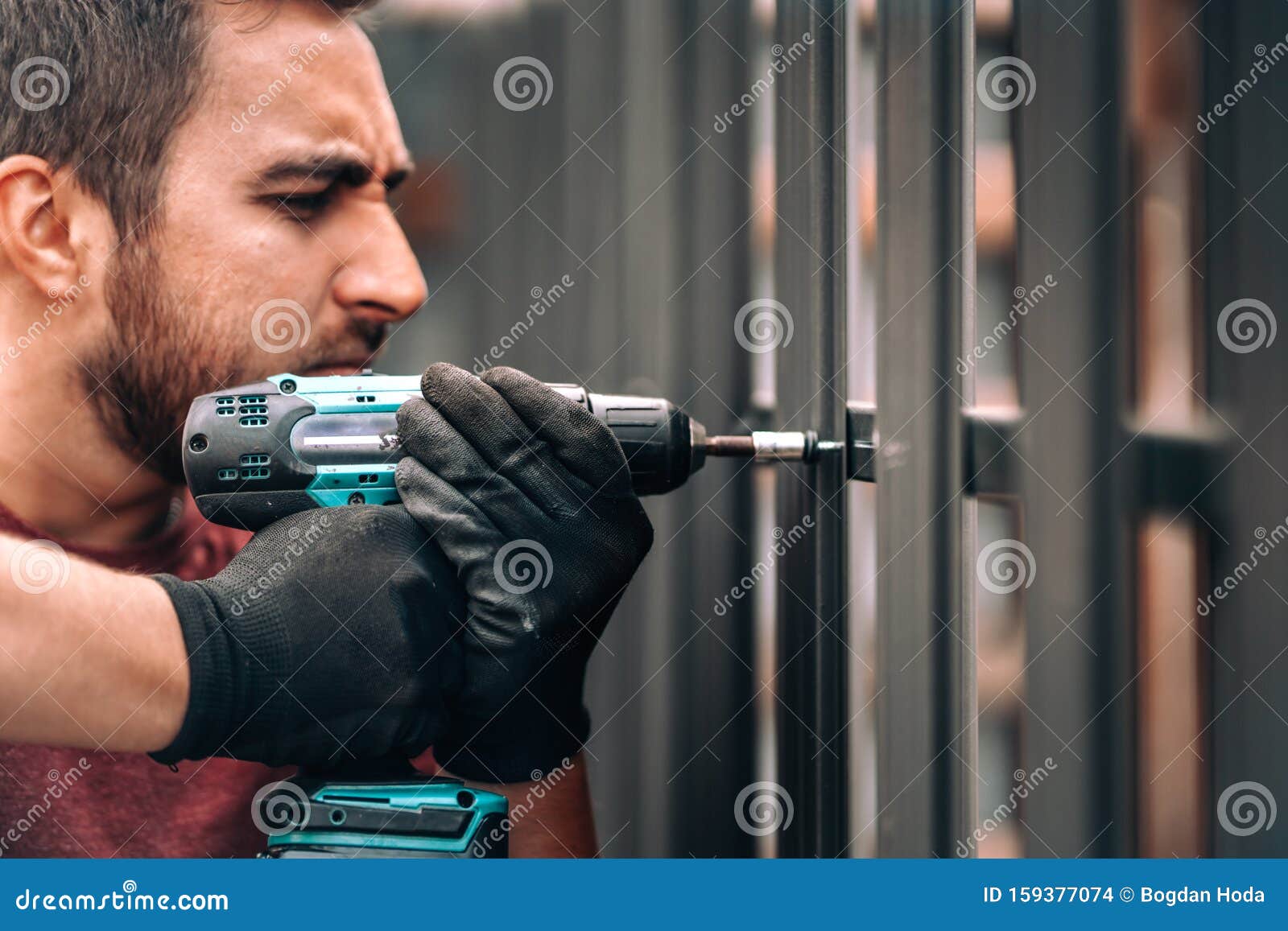 Construction Worker Using an Cordless Screwdriver for Installing Metal ...