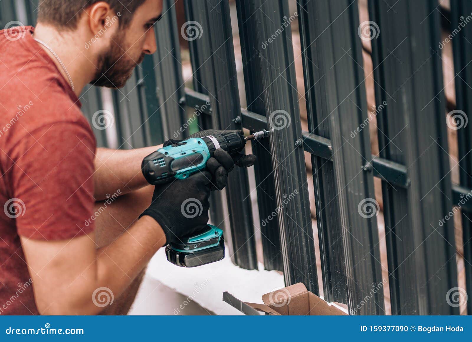 Construction Worker Using an Electric Screwdriver for Installing Metal ...