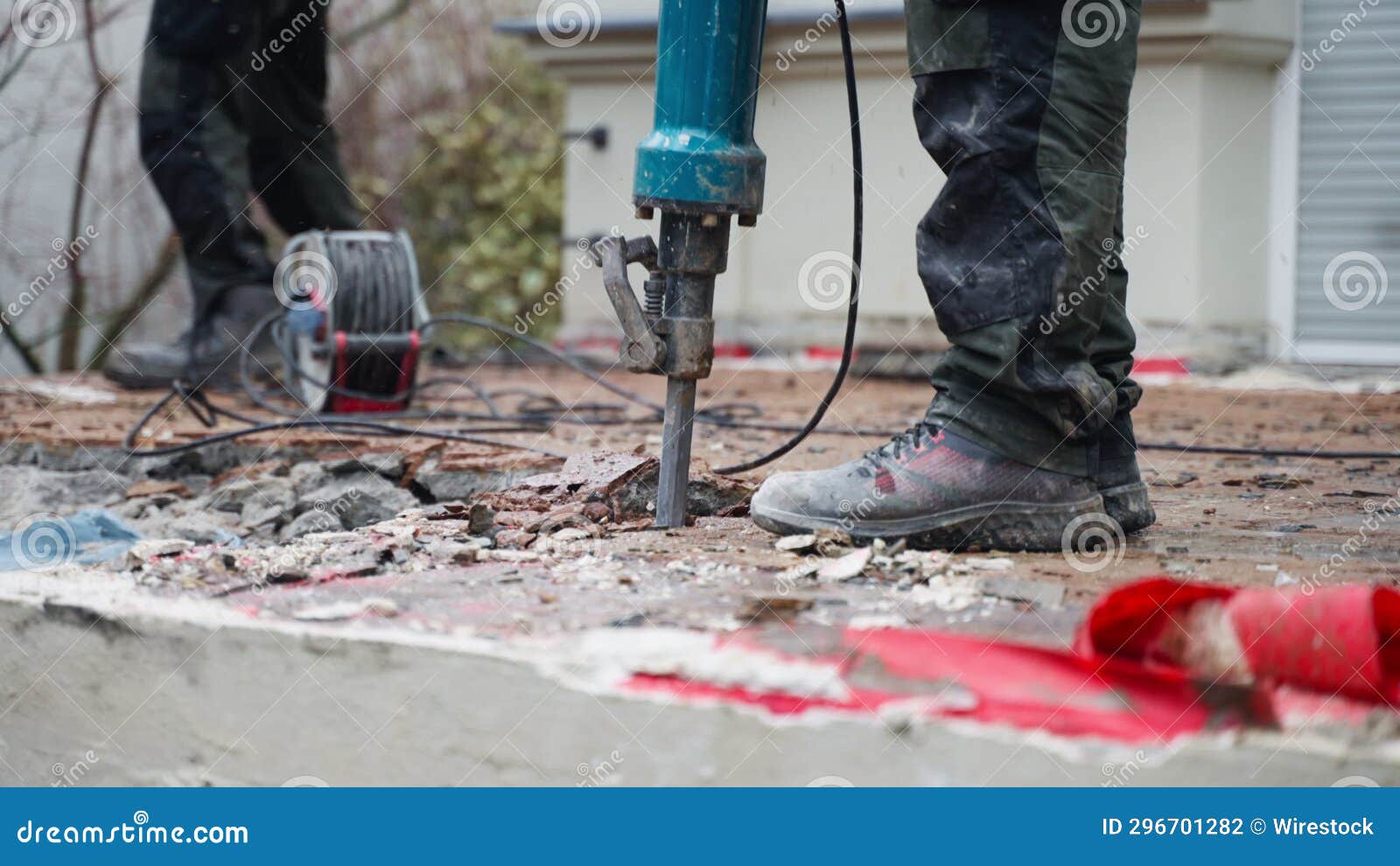 A Construction Worker Using a Jackhammer To Remove Old Concrete Near ...