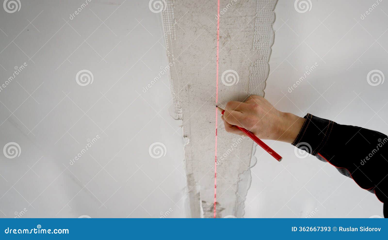 Construction Worker Using Laser Level and Pencil Marking Ceiling Line ...