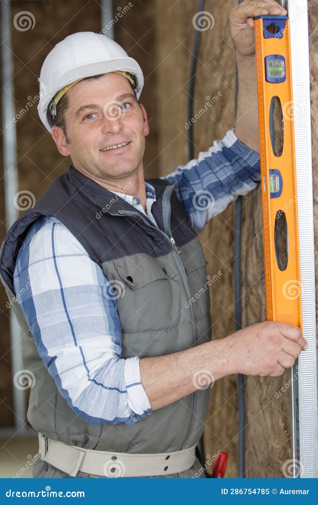 Construction Worker Using Spirit Level on Thermally Insulated Wall ...