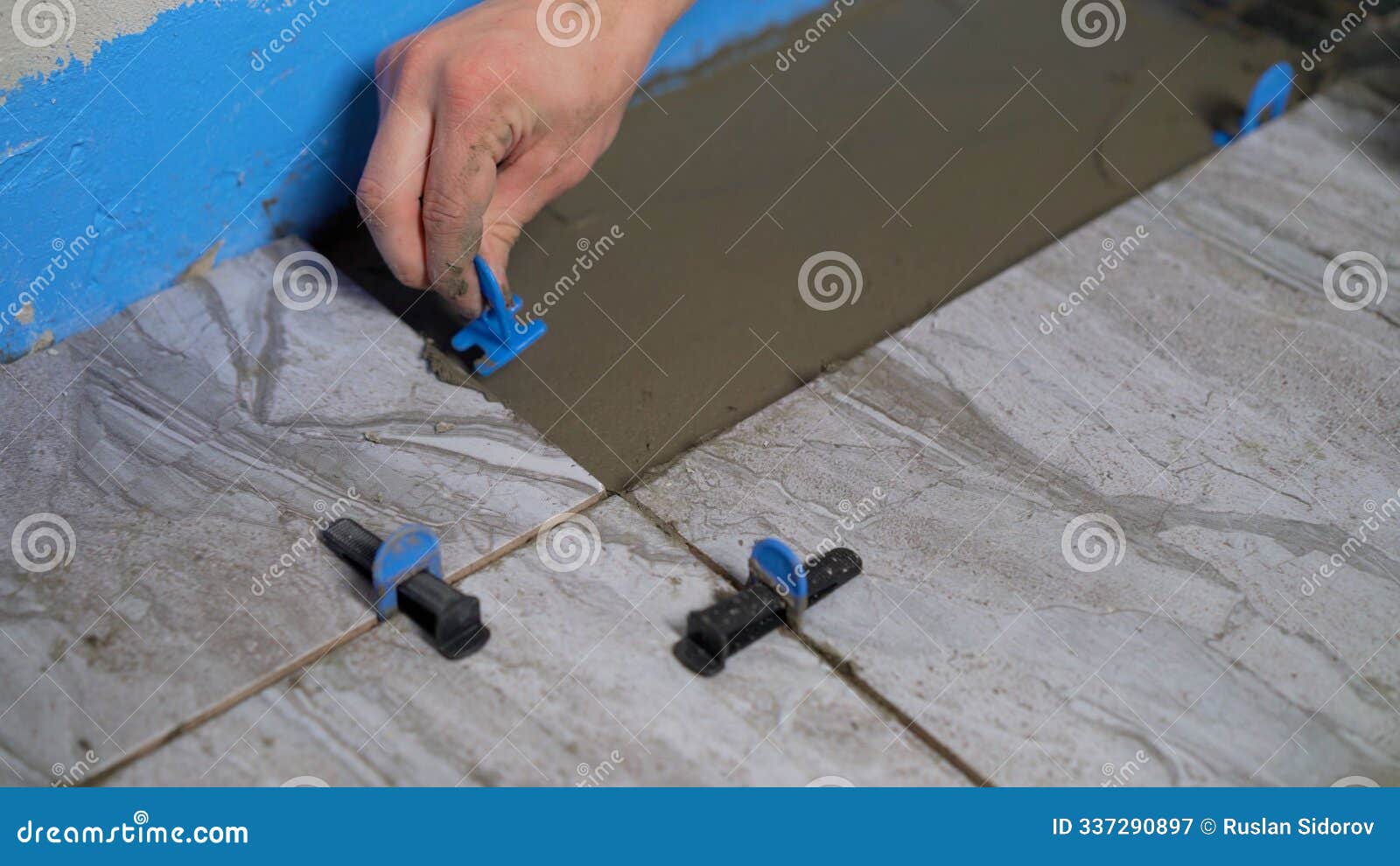 Construction Worker Placing Tile Leveling System while Laying Floor ...