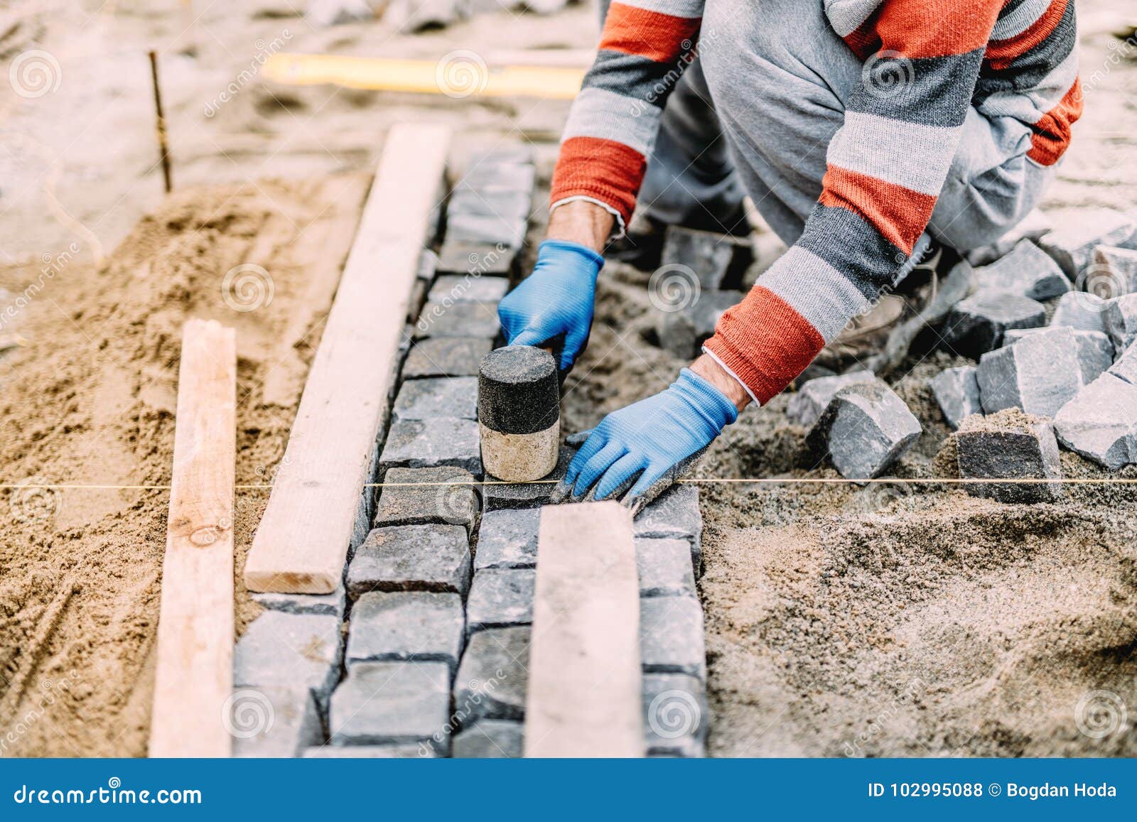 Construction Worker Using Tools for Stone Pavement. Granite Blocks ...