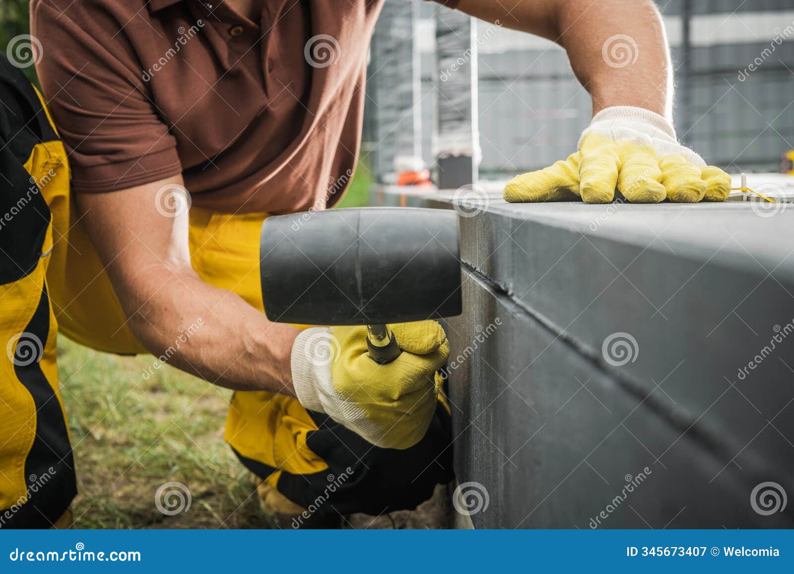 Worker Installing Pavement Blocks with a Rubber Mallet in a Modern ...