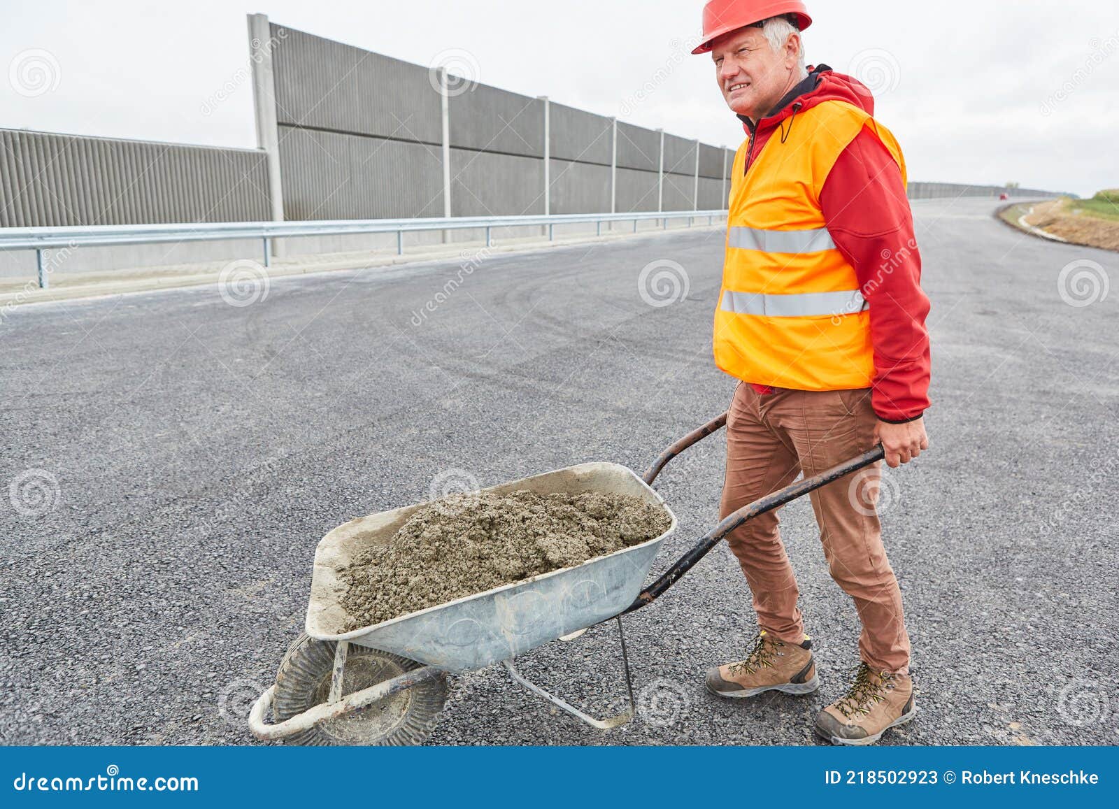 Construction Worker with Wheelbarrow Full of Concrete on Construction ...