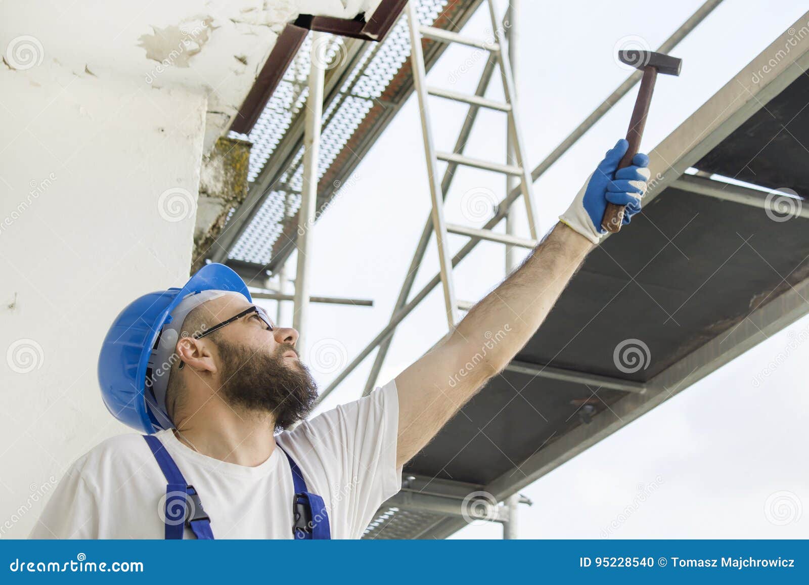 Construction Worker in a Work Attire, Protective Gloves and a Helmet on ...