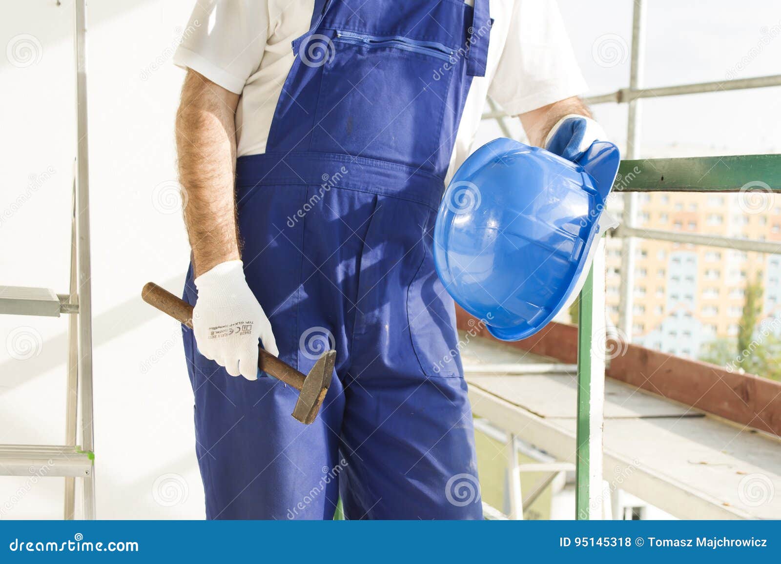 Construction Worker in a Work Attire, Protective Gloves Holds a Helmet ...