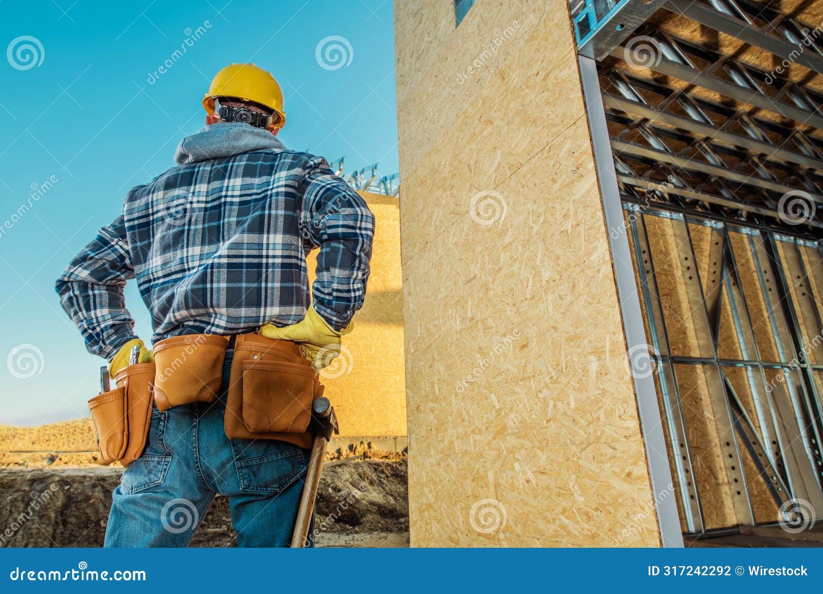 Construction Worker Working on a Building Site with a Wall in Progress ...
