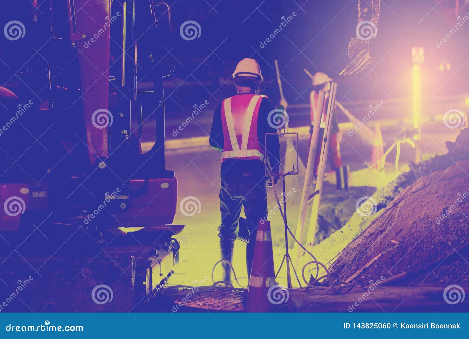 Construction Worker is Working at Night in Construction Site with ...