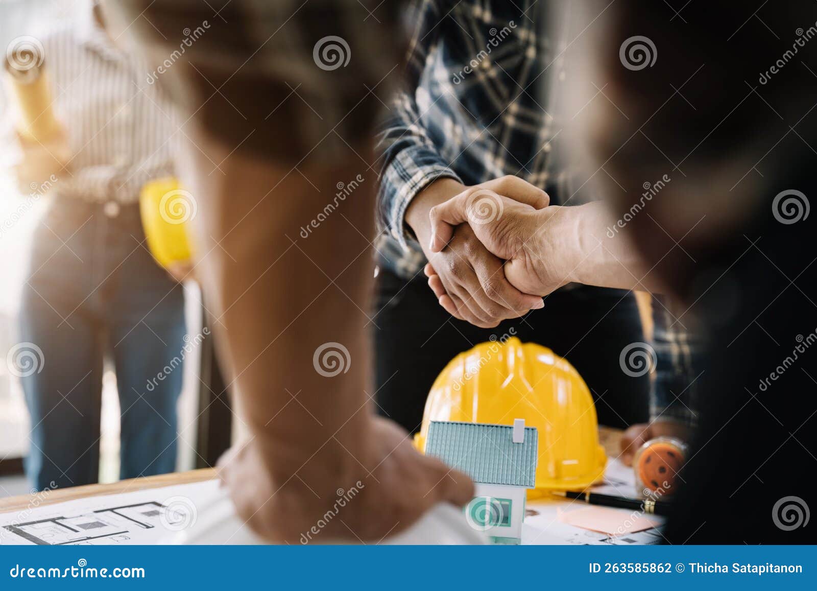 Two Engineers Shake Hands While Looking At A Floor Plan During ...