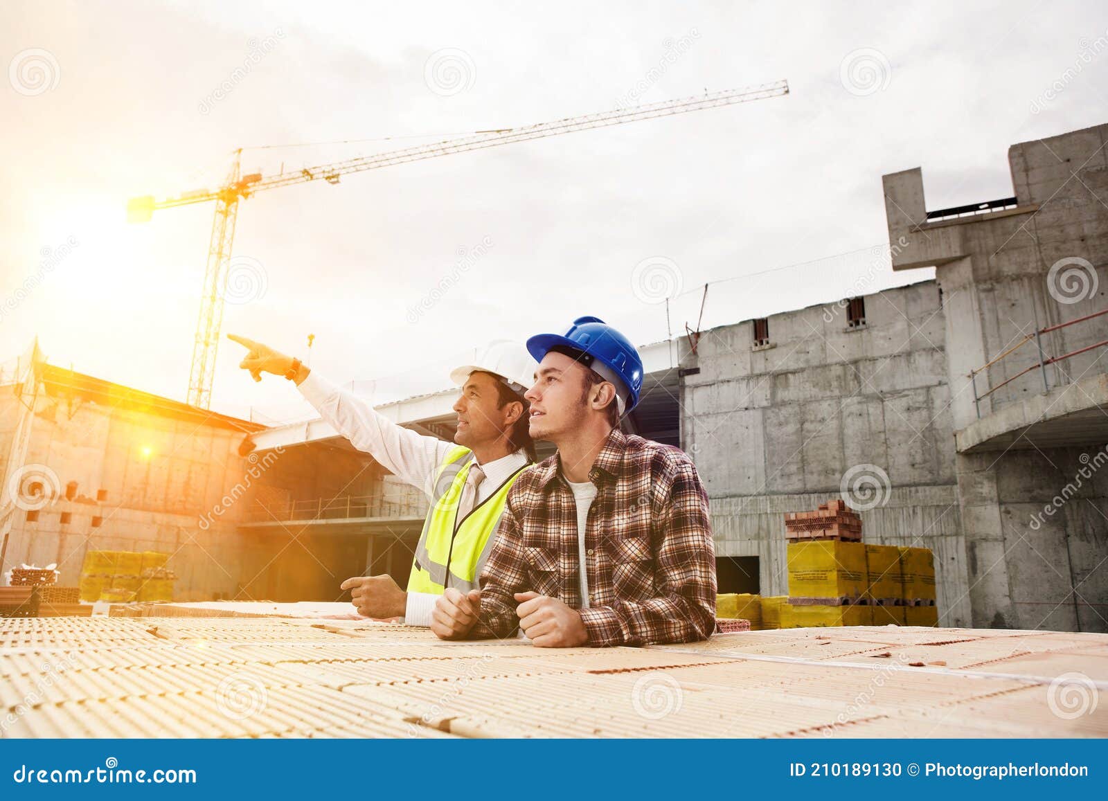 Construction Workers Discussing Job at Building Site Stock Photo ...