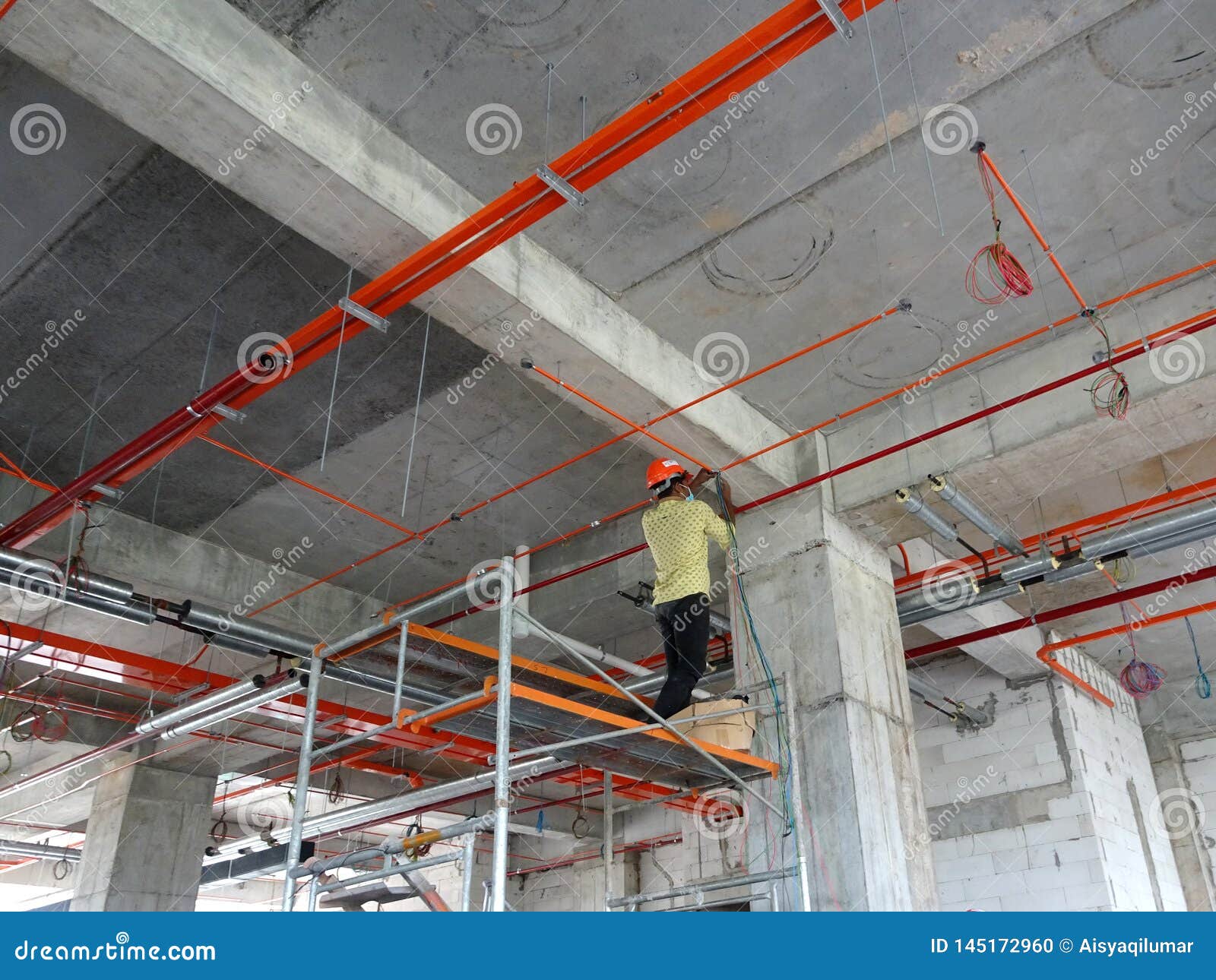 Construction Workers Installing Electrical Cable Tray and Doing Wiring ...