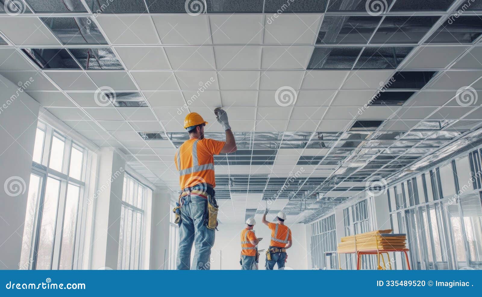 Construction Workers Installing Suspended Ceiling Tiles in a Commercial Building Stock ...