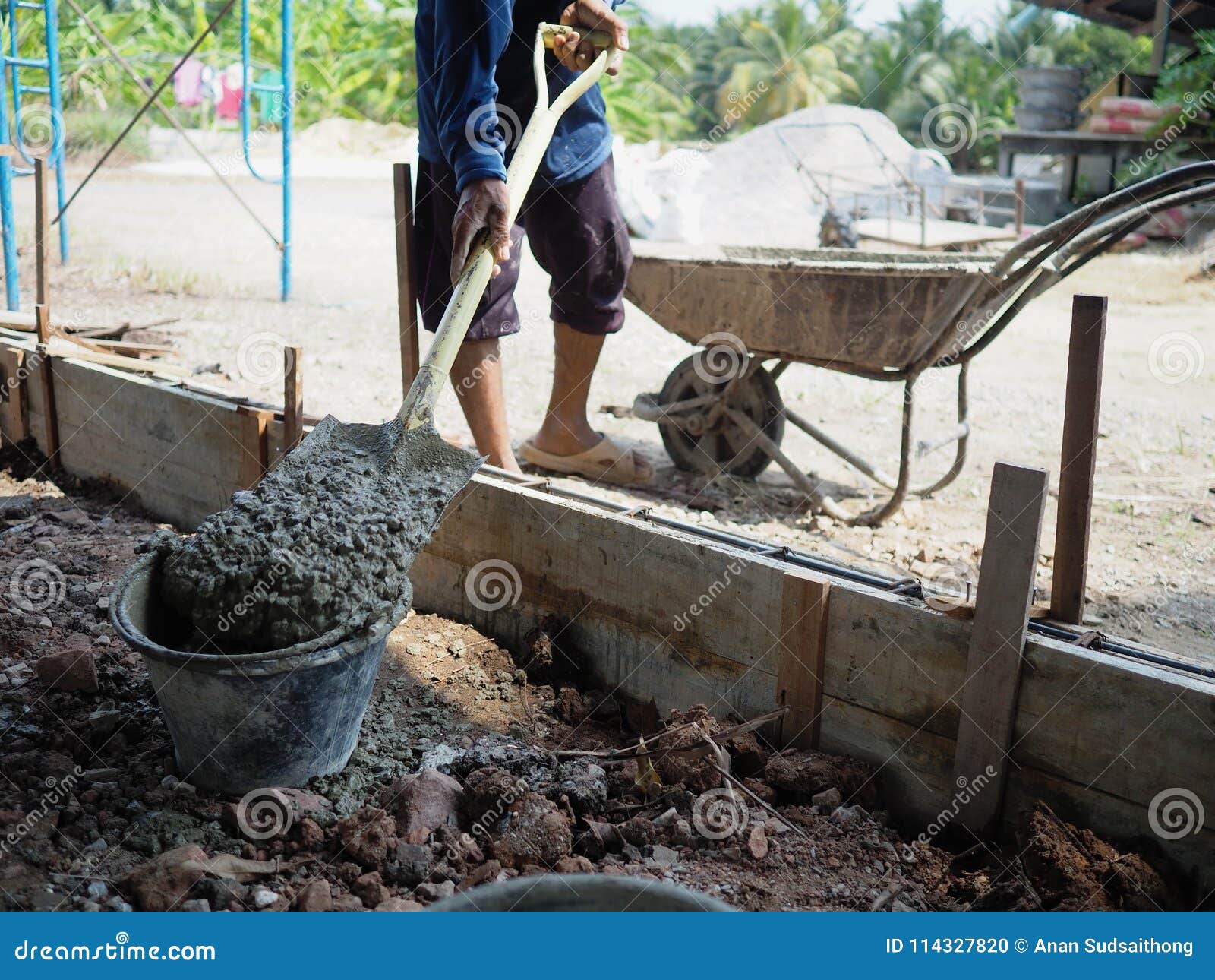 Construction Workers Loading Wet Cement To Bucket in Building Site ...
