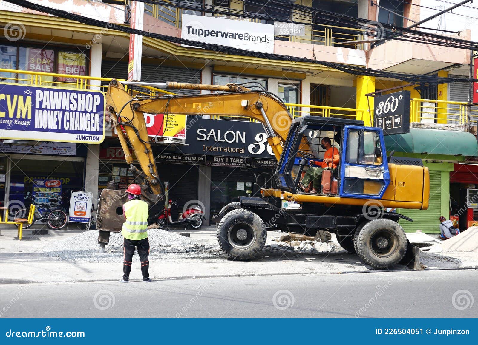 Construction Workers Operate an Excavator while Working at a Road ...