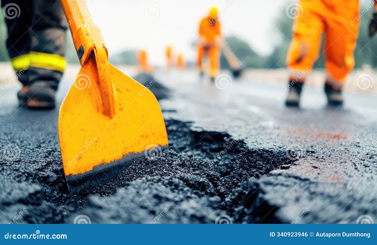 Construction Workers Repair a Road Using Shovels, Showcasing Teamwork ...