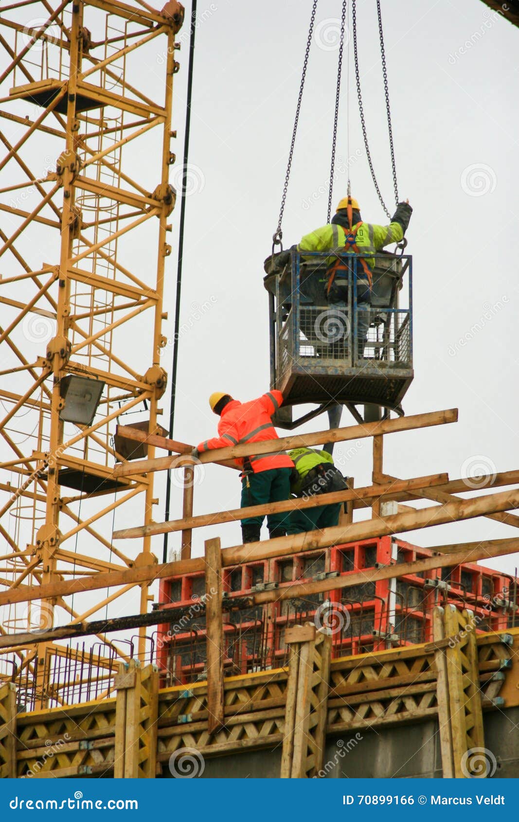 Construction Workers on Roof Casting Concrete Lowered from a Crane ...