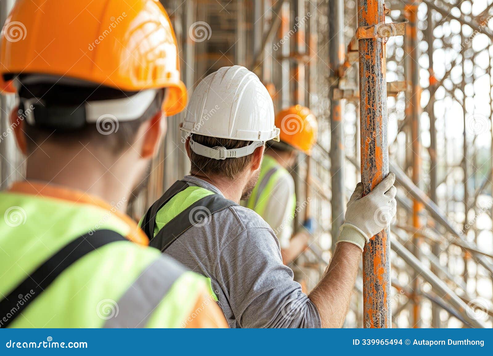 Construction Workers in Safety Gear Inspect Scaffolding at a Building ...