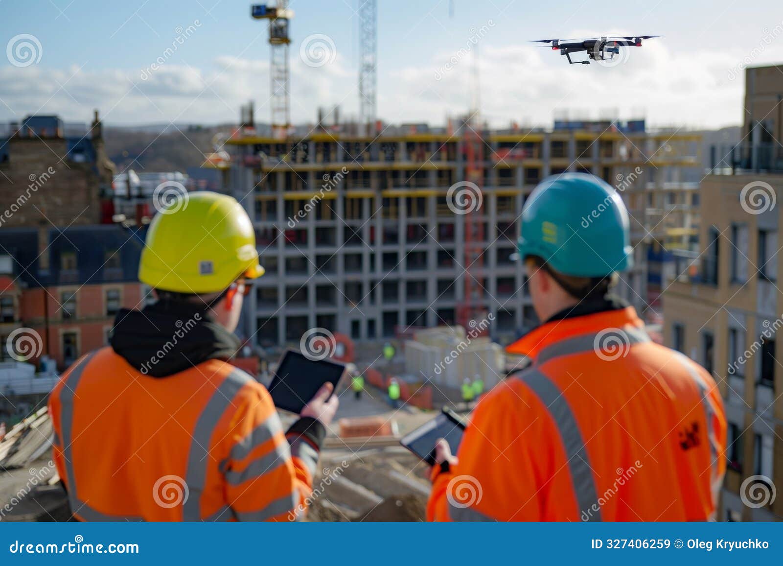 Construction Workers in Safety Gear Using Drones and Tablets at a Building Site. the Photo Shows ...