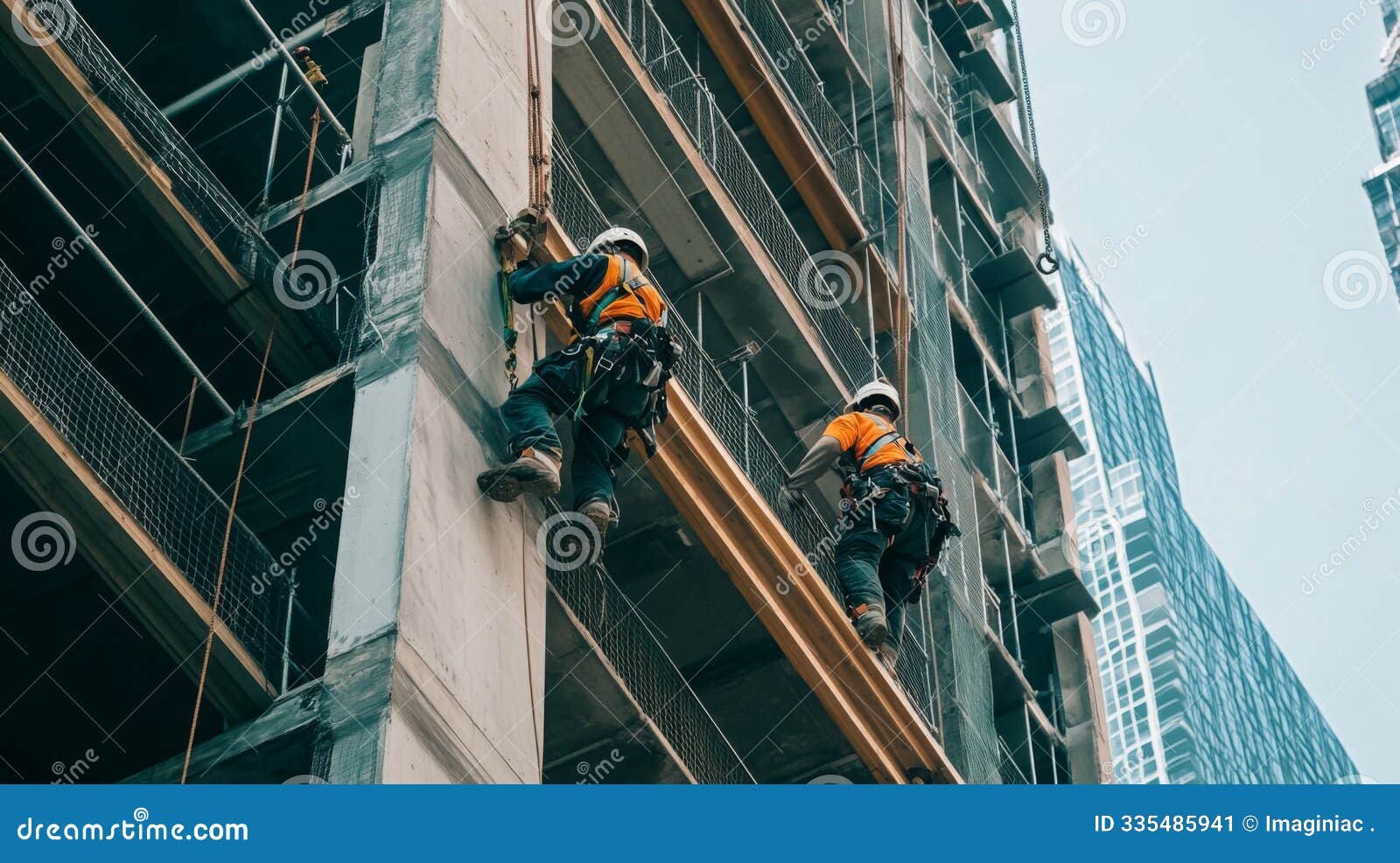 Construction Workers Scaling a Tall Building Using Safety Harnesses ...