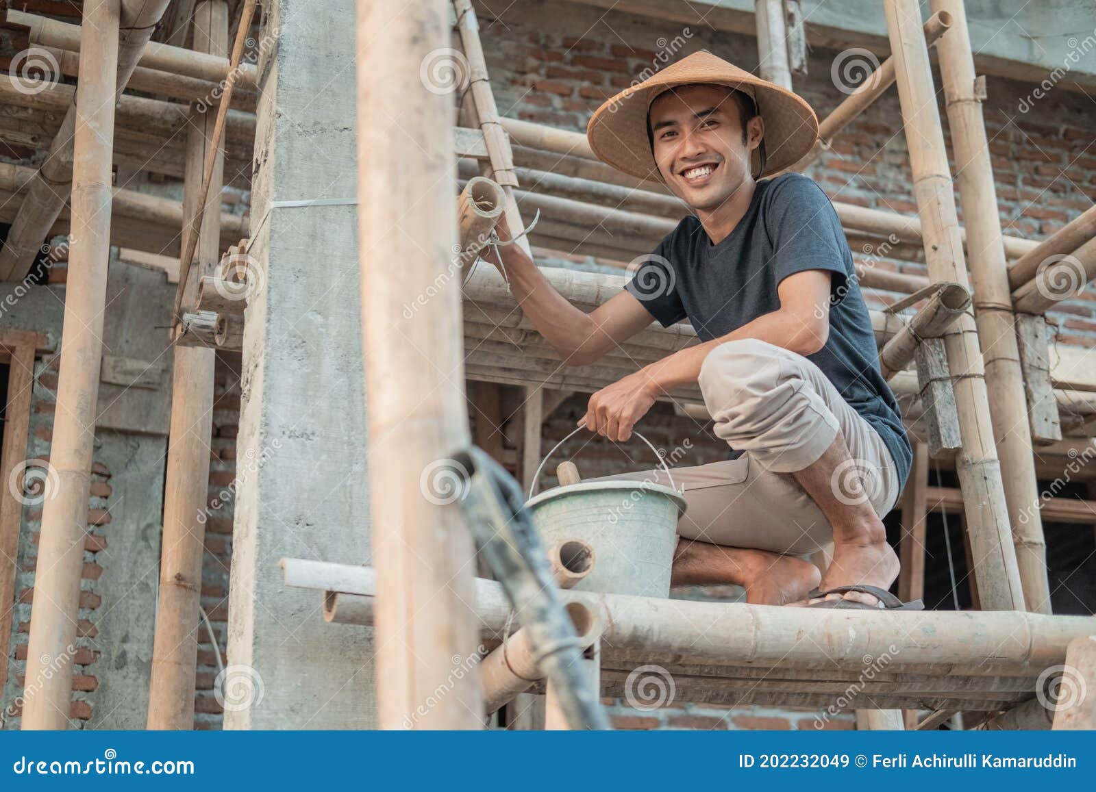 Construction Workers Smile at the Camera As they Squat on the Bamboo ...